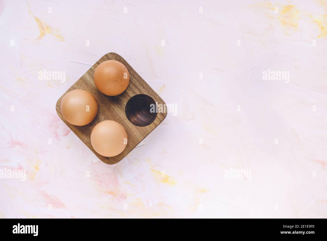 Three brown eggs in a wooden storage organizer box Stock Photo - Alamy