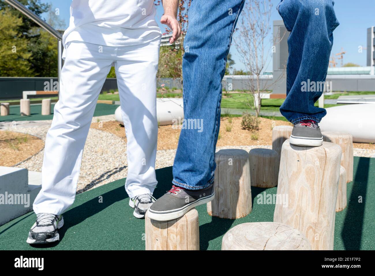a patient is doing balance exercises with a physiotherapist, outside ...