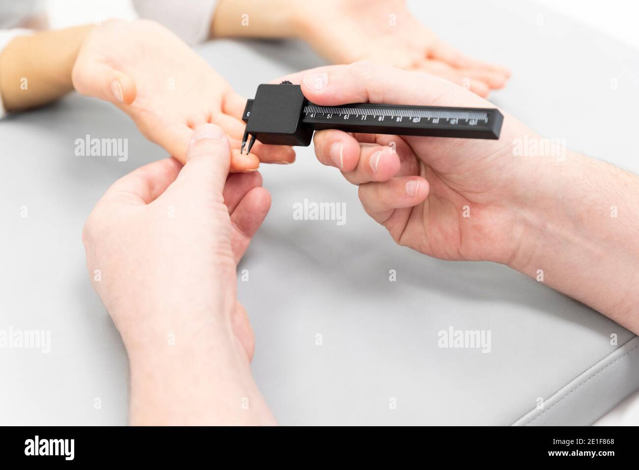 a doctor testing the sensitivity of a patient's finger Stock Photo - Alamy