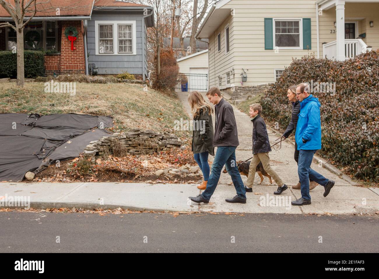 A family walk together with dog through suburban neighborhood Stock ...