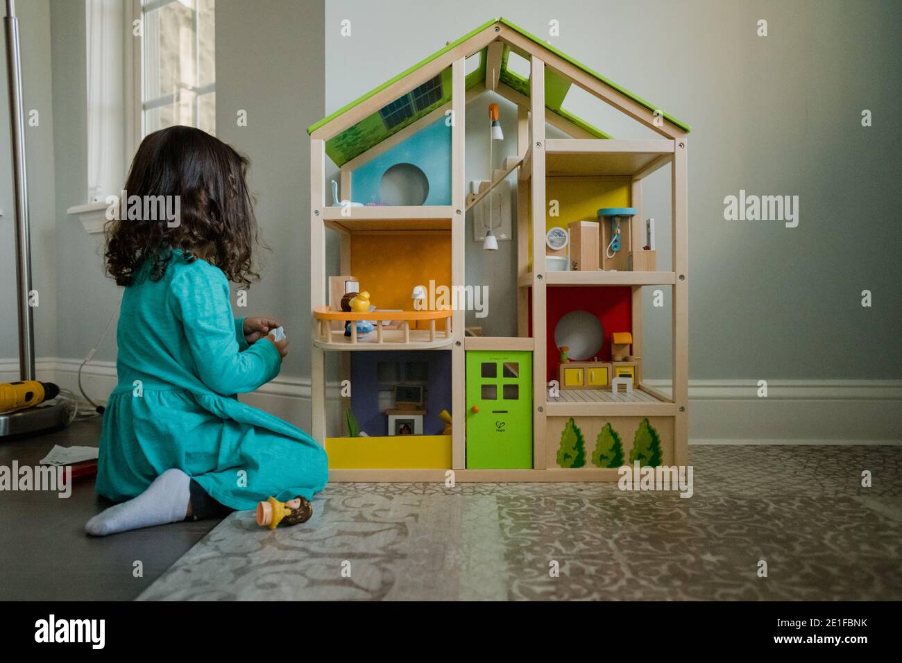 Young child playing with dollhouse Stock Photo - Alamy