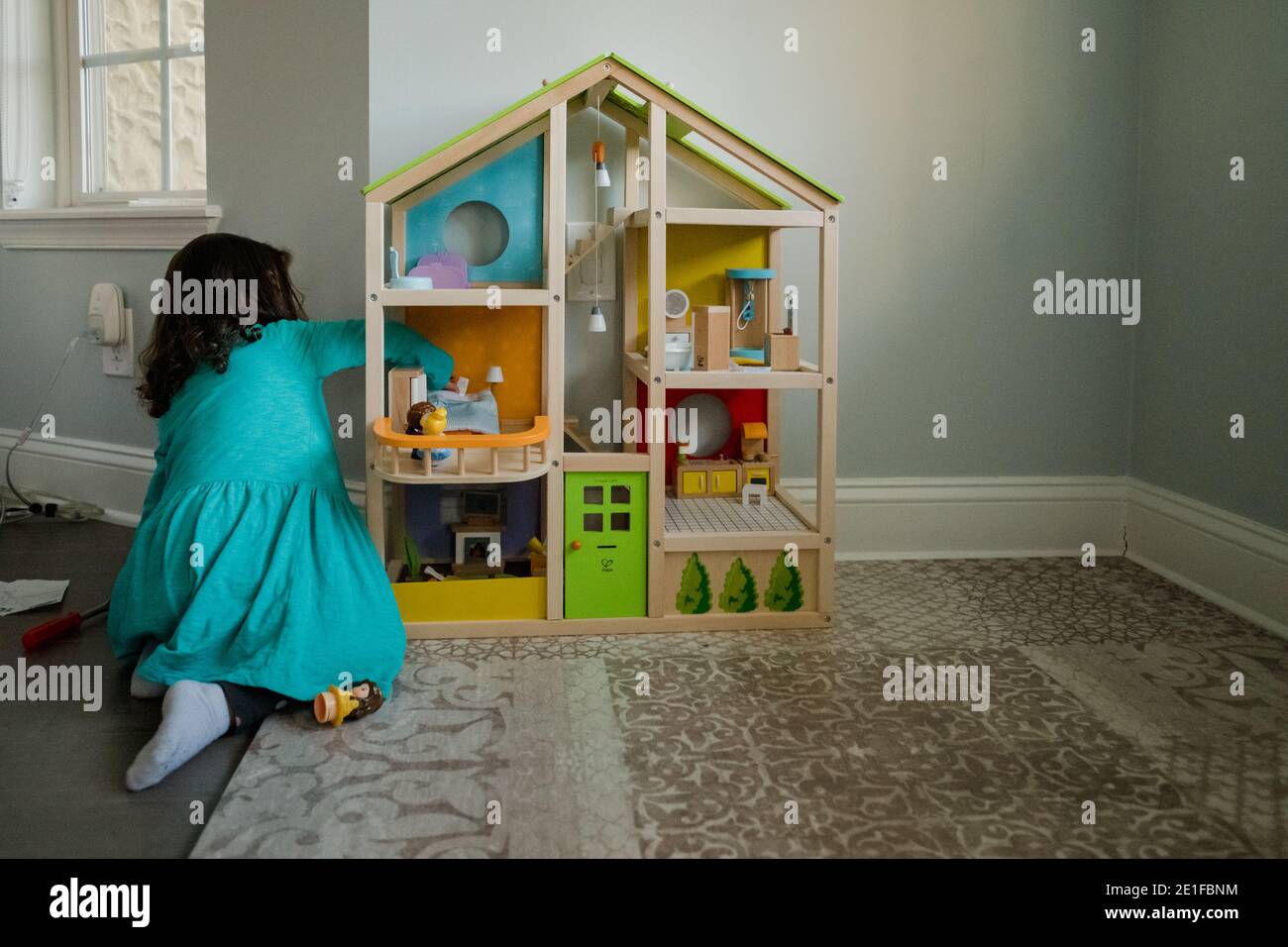 little girl playing with a dollhouse Stock Photo - Alamy