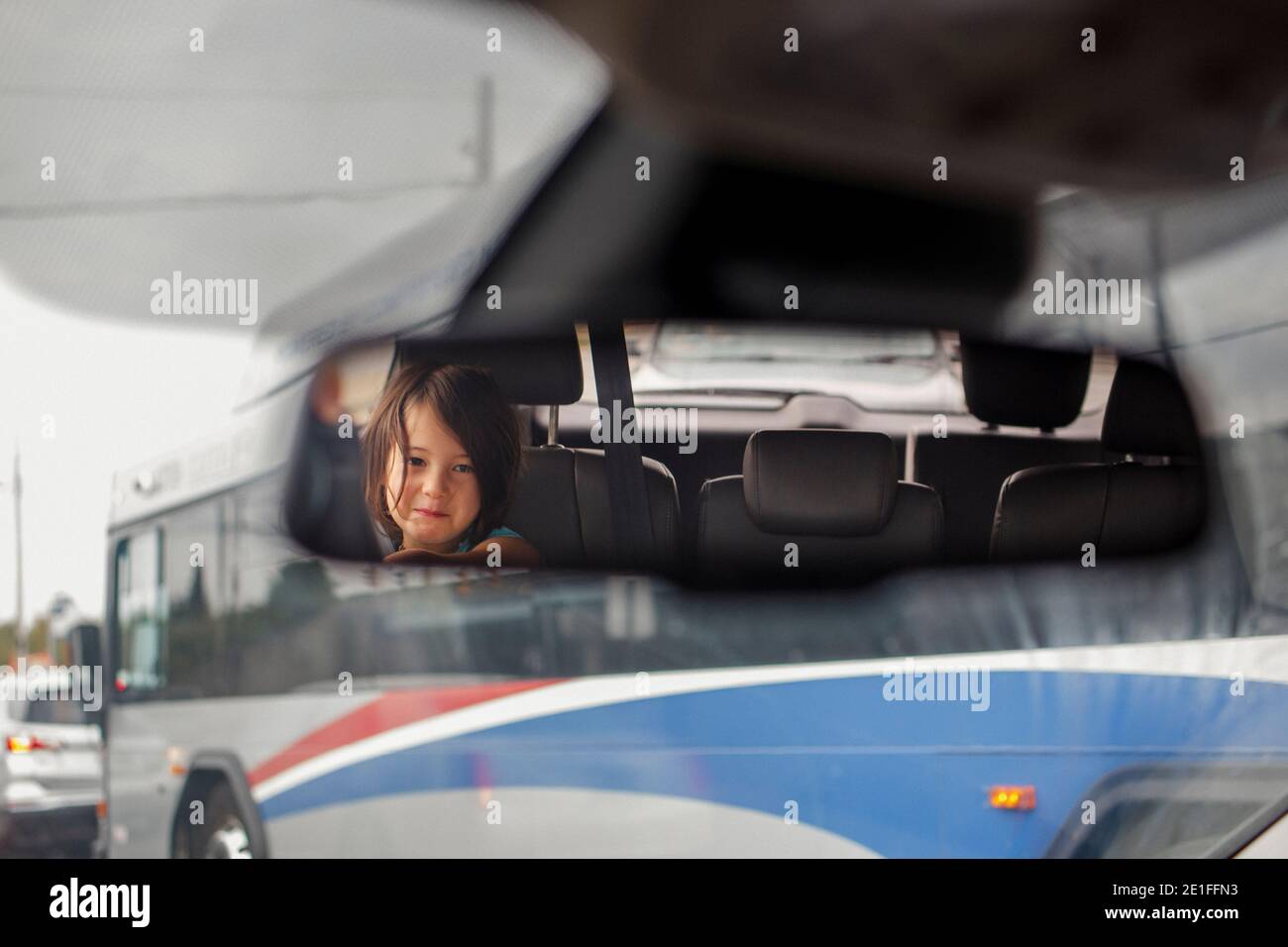 a cute little girl is reflected in the rear-view mirror of a car Stock ...
