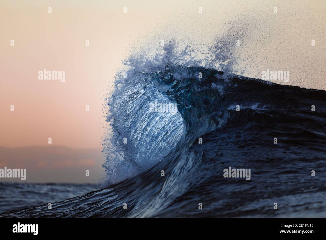 Small wave breaking during sunrise Stock Photo - Alamy