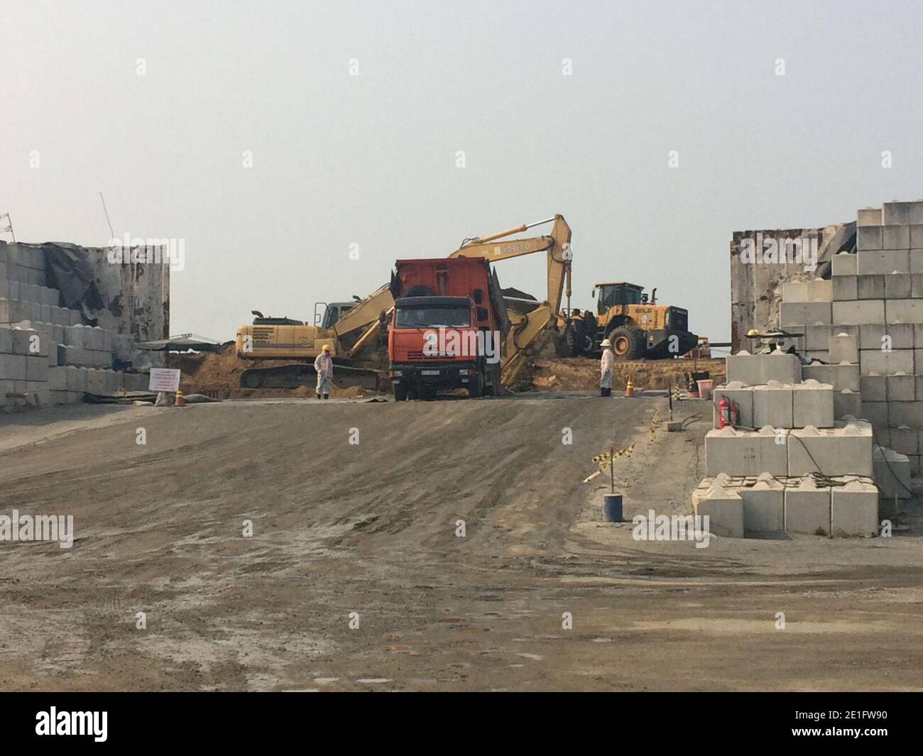 Loading and compacting contaminated soil into the treatment structure ...