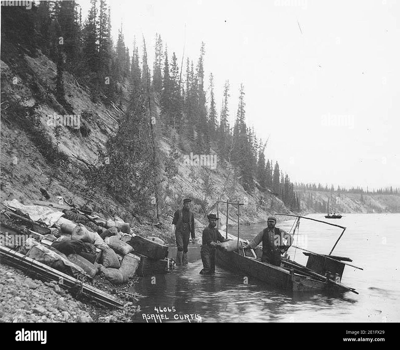 Loading supplies into boat along the Thirty Mile River, Yukon Territory ...
