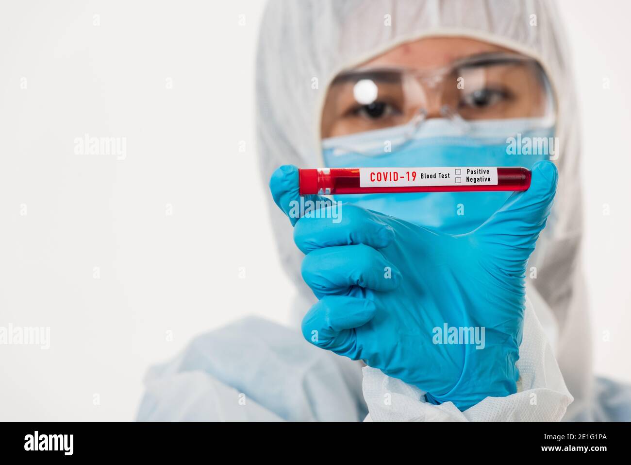 Medical scientist in PPE uniform wear a mask holding test tube ...