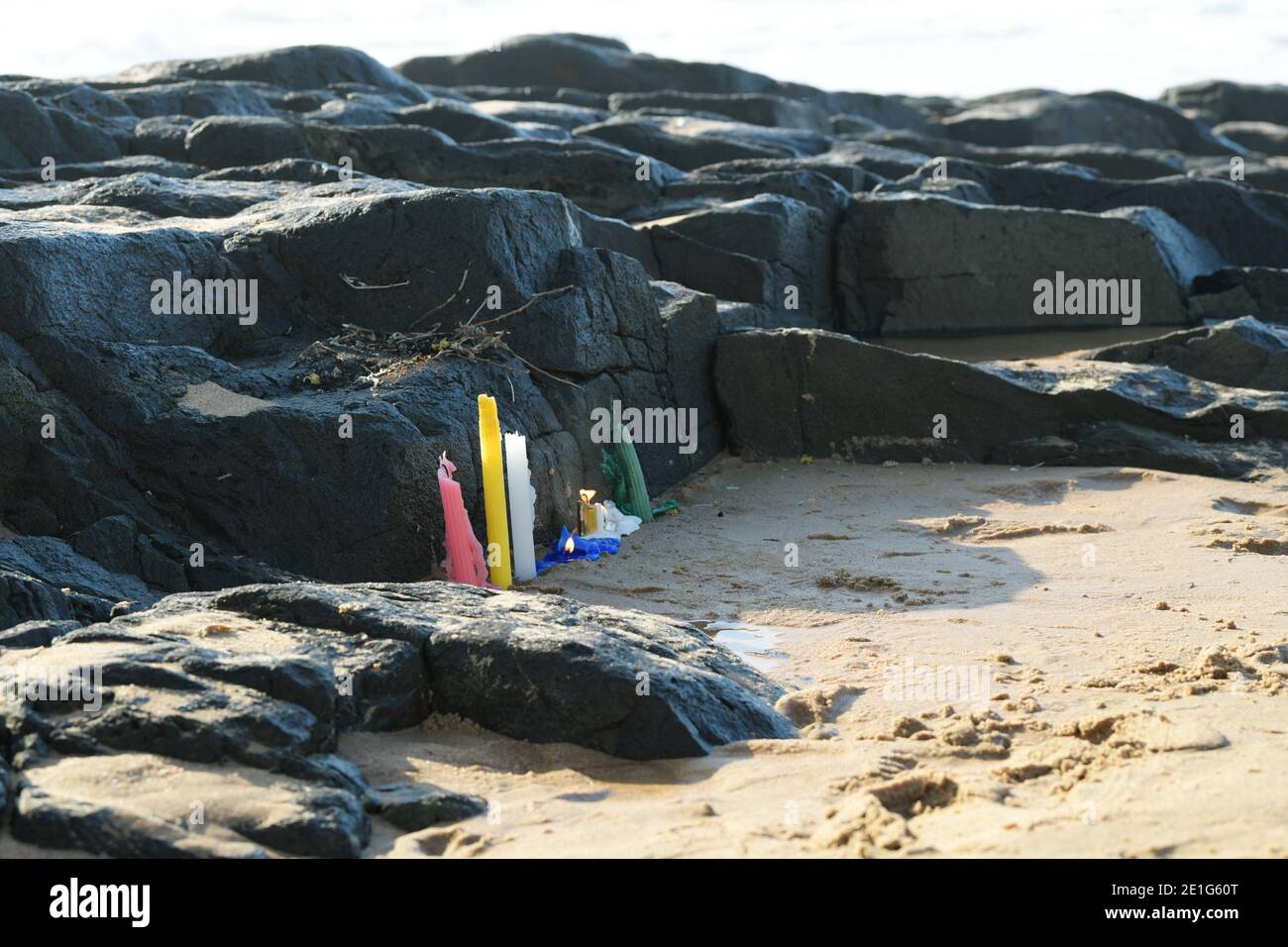 Objects, candles on beach used for religious ritual, ancestor worship ...