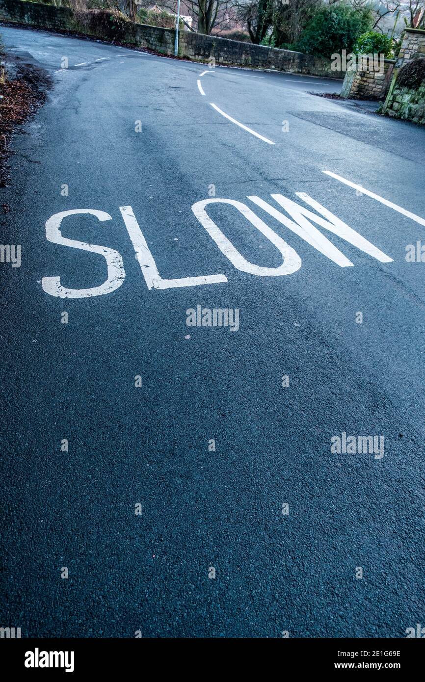Slow road marking word on a road with a bend taken from above Stock ...