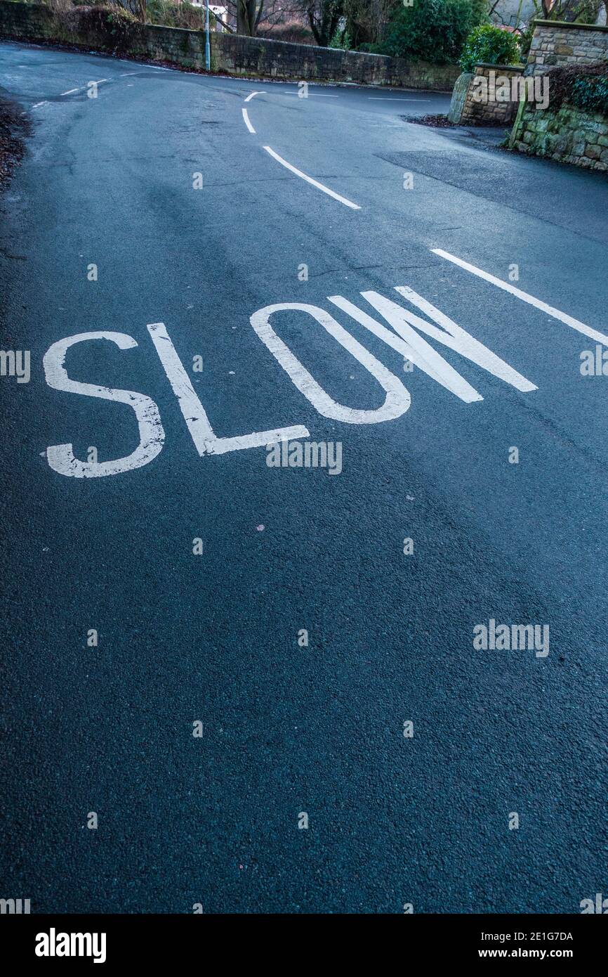 Slow road marking word on a road with a bend taken from above Stock ...