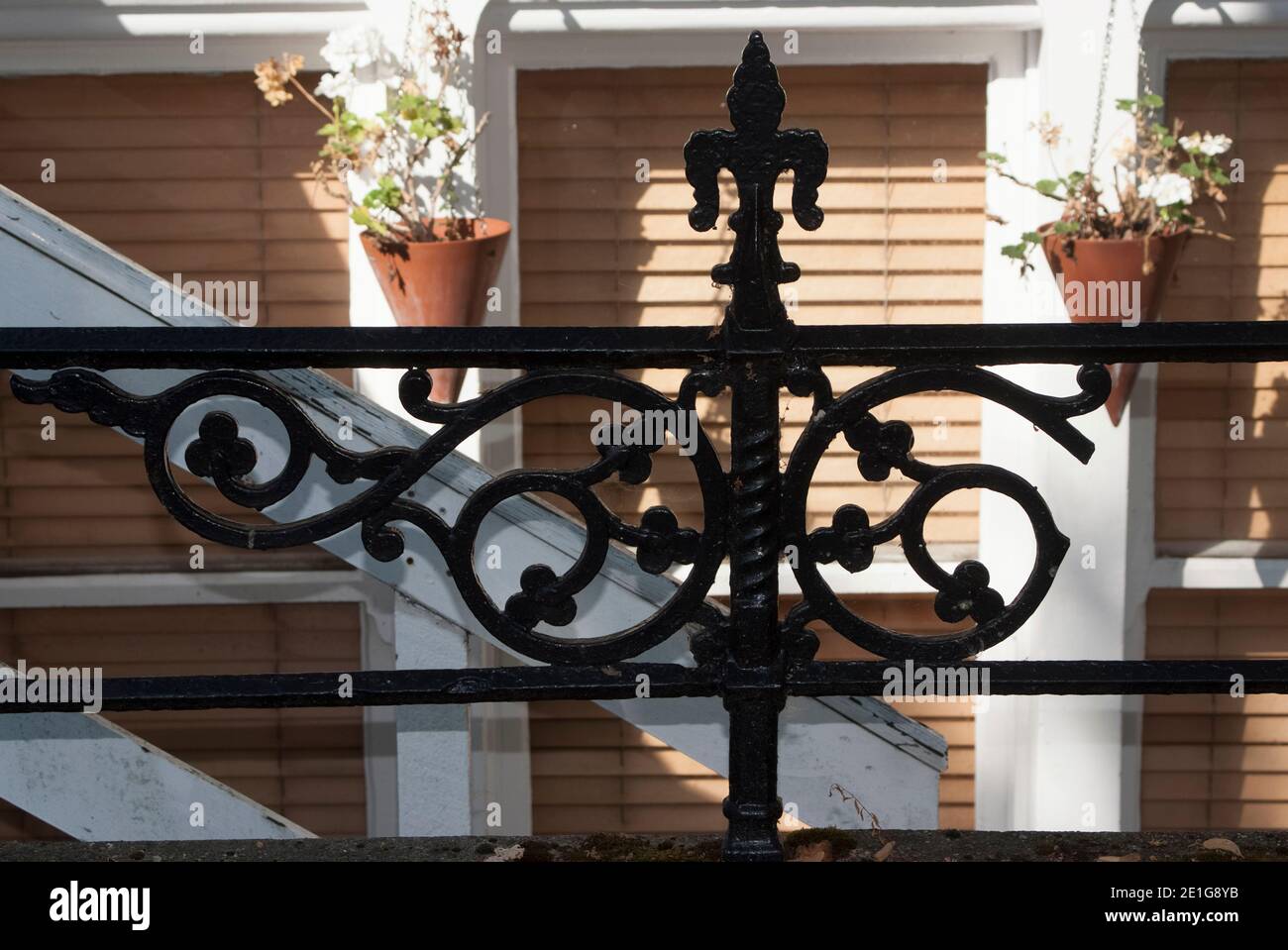 Railings with ornamental scrolls and a house exterior Stock Photo - Alamy