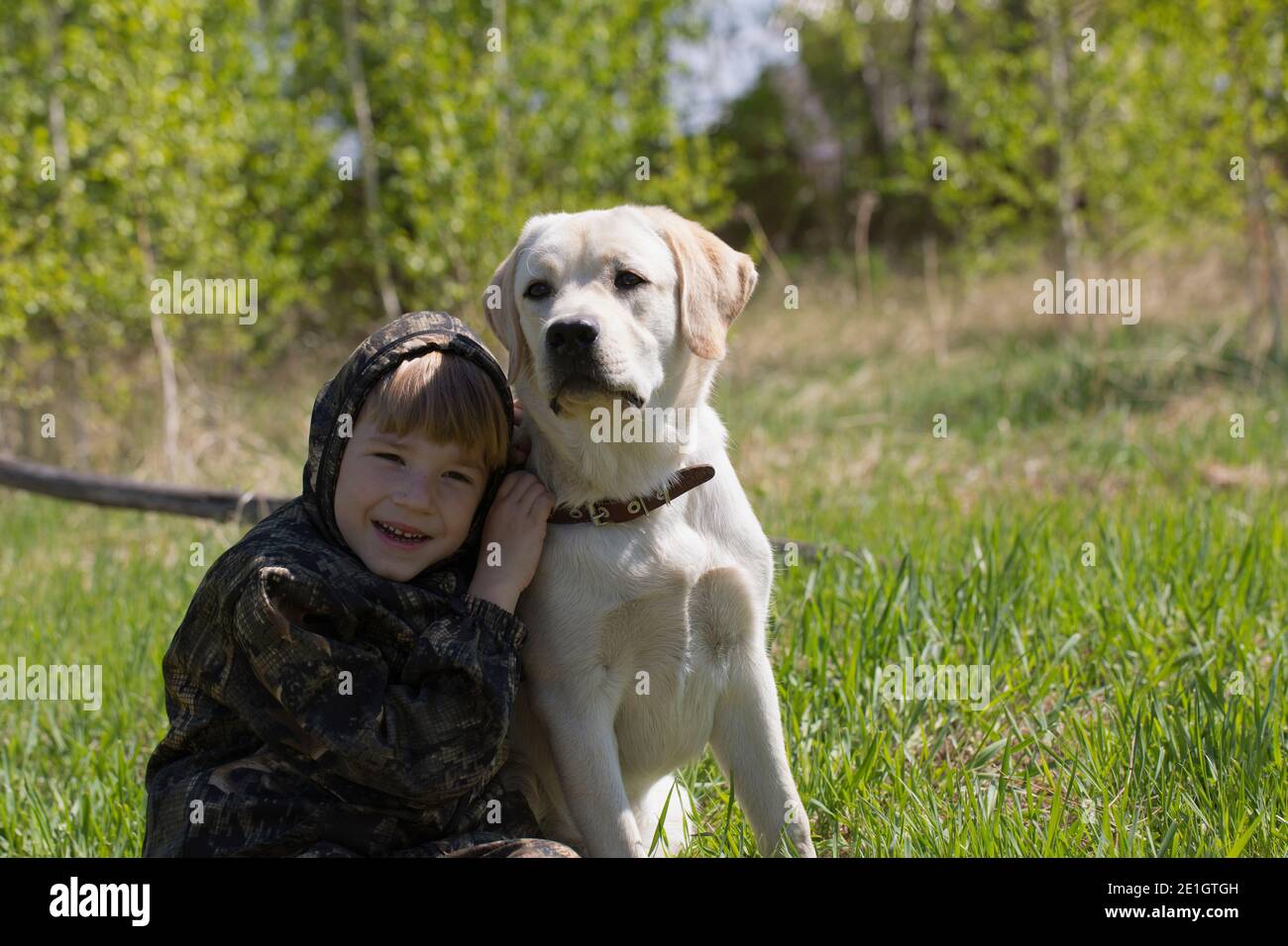 boy hugs large dog. trust and love of man for animals. Labrador ...
