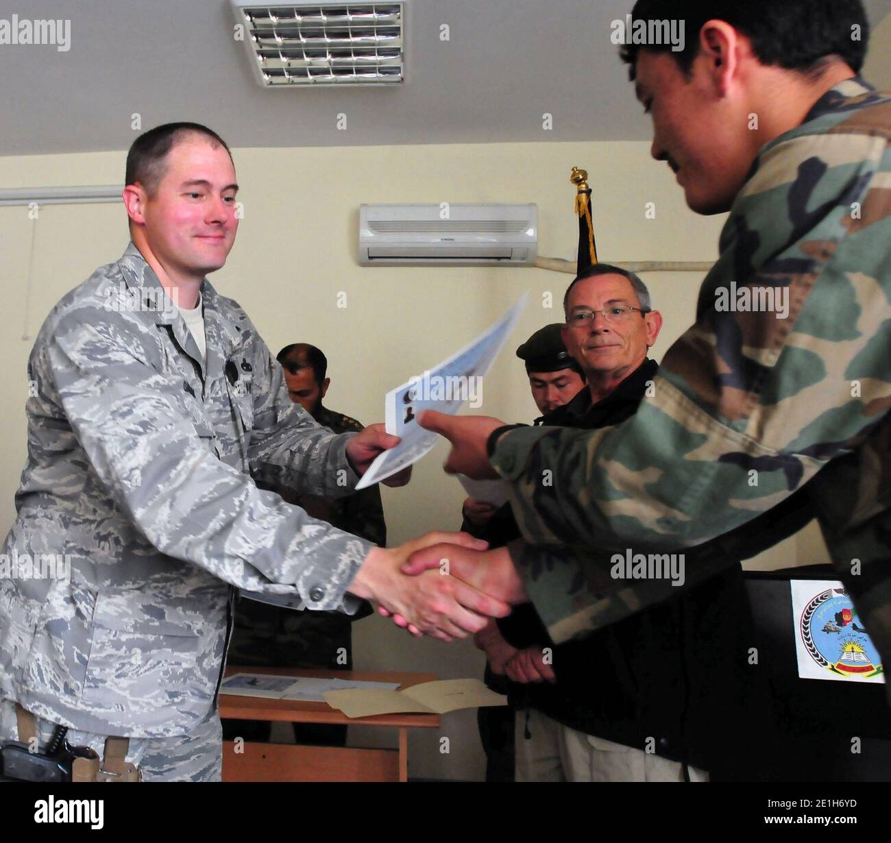 Lt. Col. gives a graduation certificate to an Afghan National Army ...