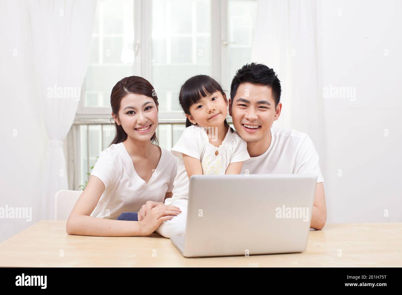 Little girl using laptop with her parents high quality photo Stock ...