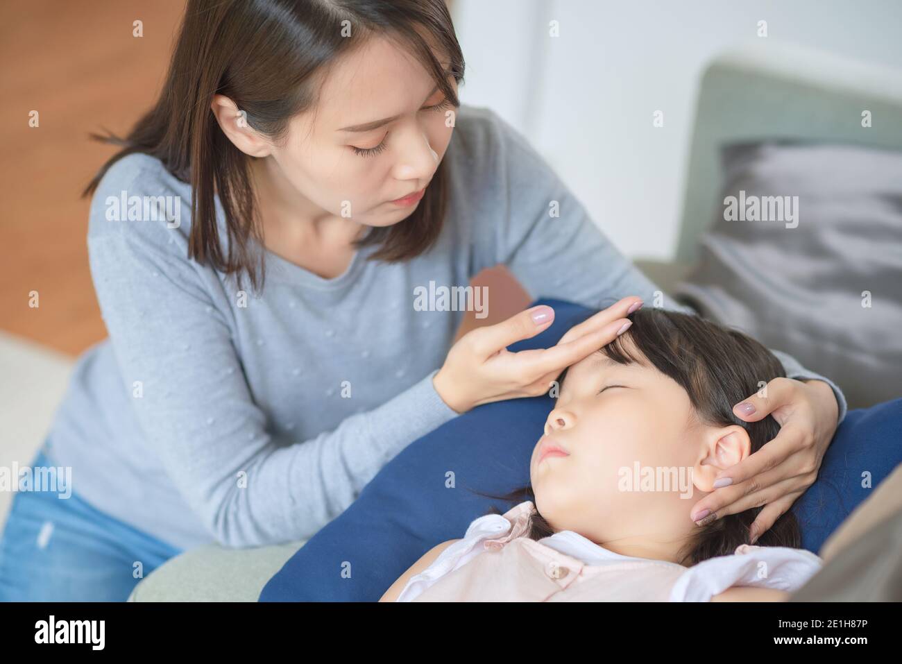 Asian mother take care of her kid which got fever and illness at home Stock Photo - Alamy