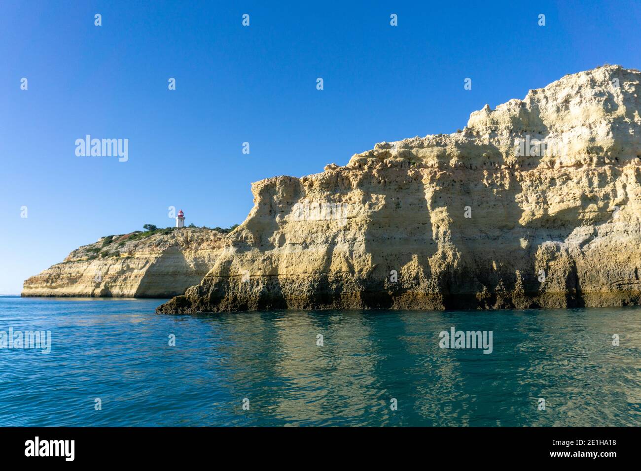 A view of the Alfanzina lighthouse on the beautiful Algarve coast of ...