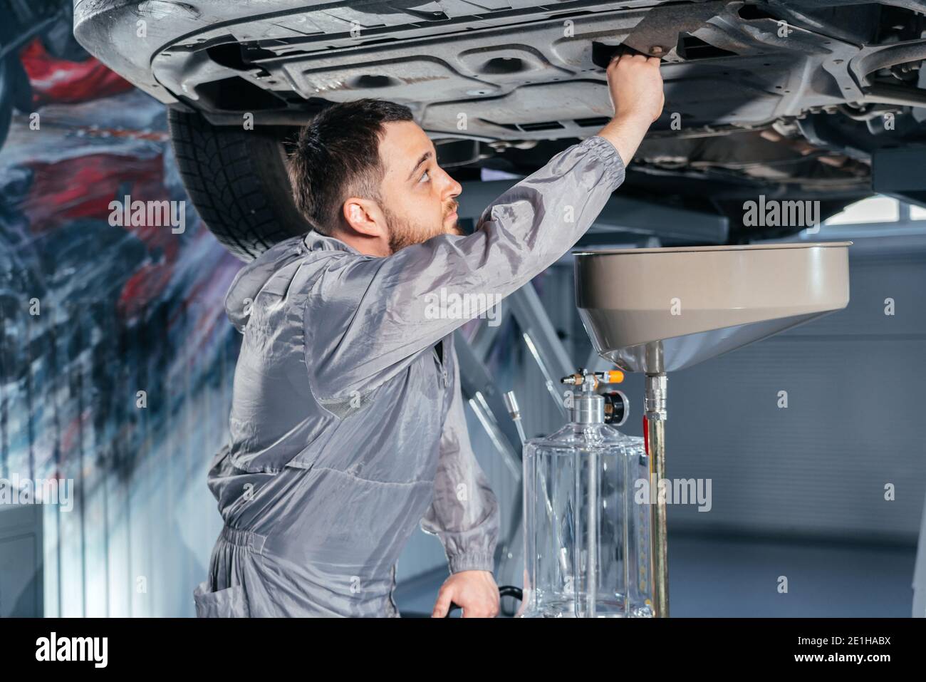 Car Mechanic Replacing Oil in Motor Engine. Auto service shop Stock ...