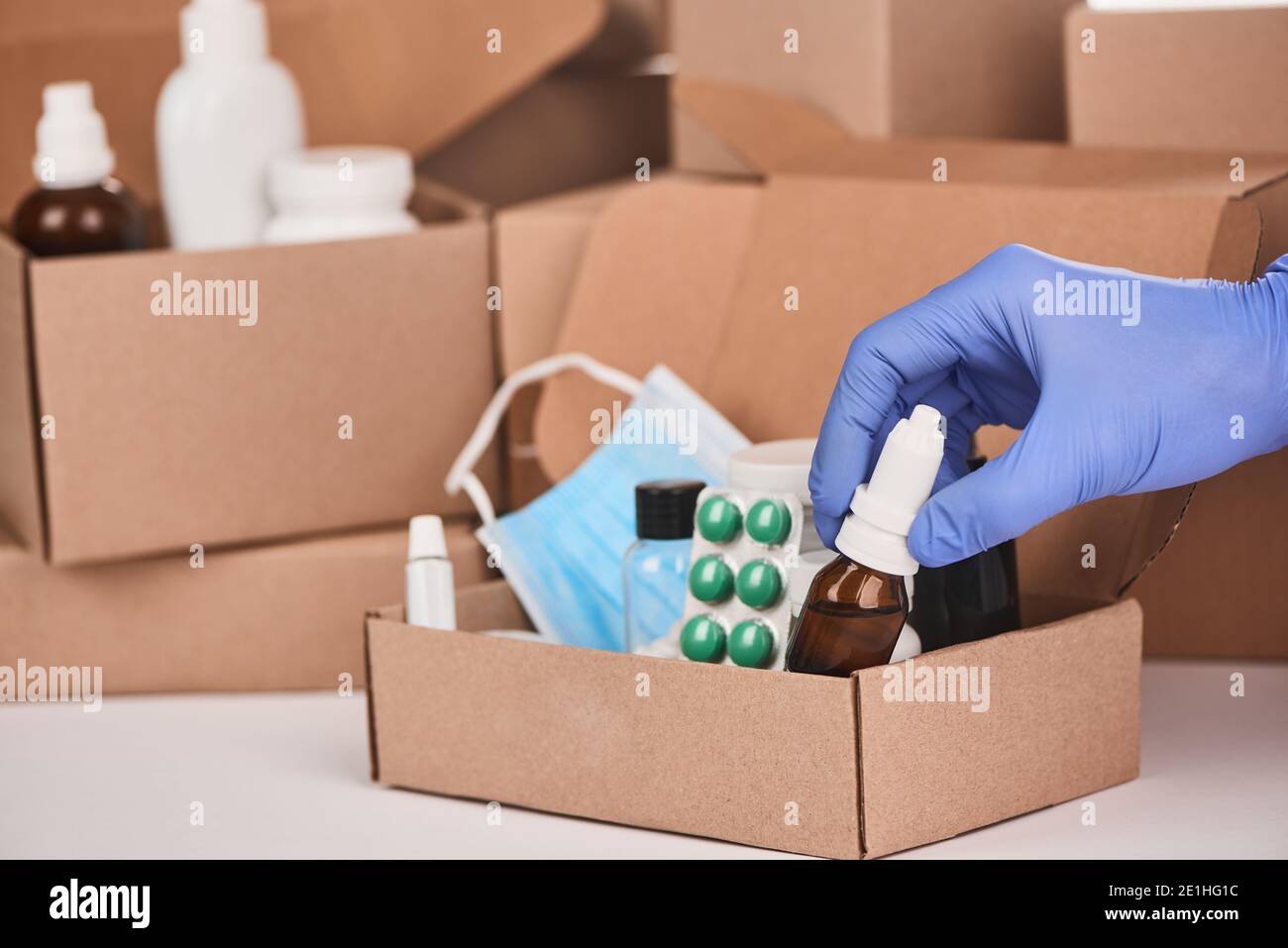 Pharmacist's hand putting a bottle of nasal drops into a box with ...