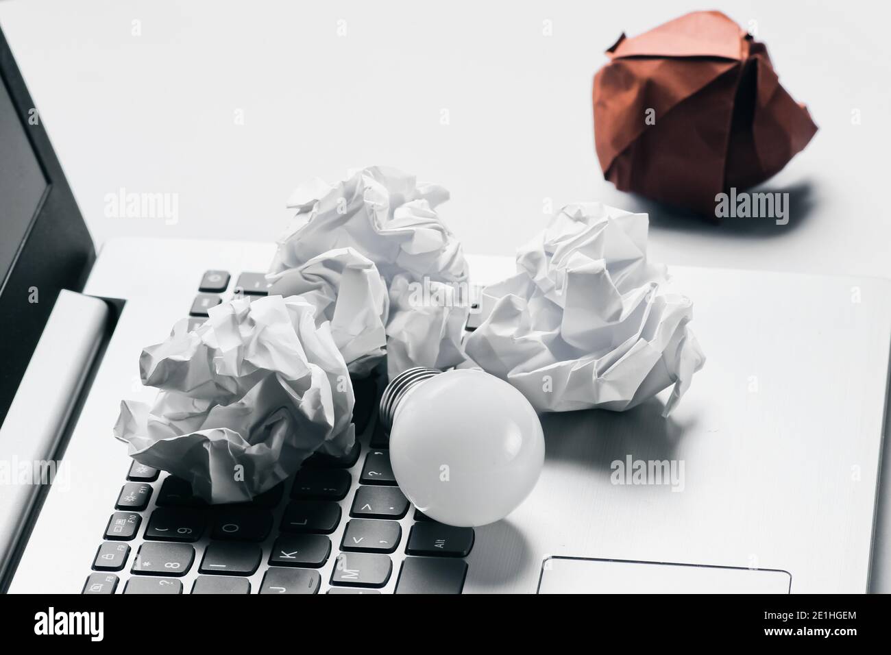 Idea business concept. Laptop, crumpled paper balls, LED light bulb on ...