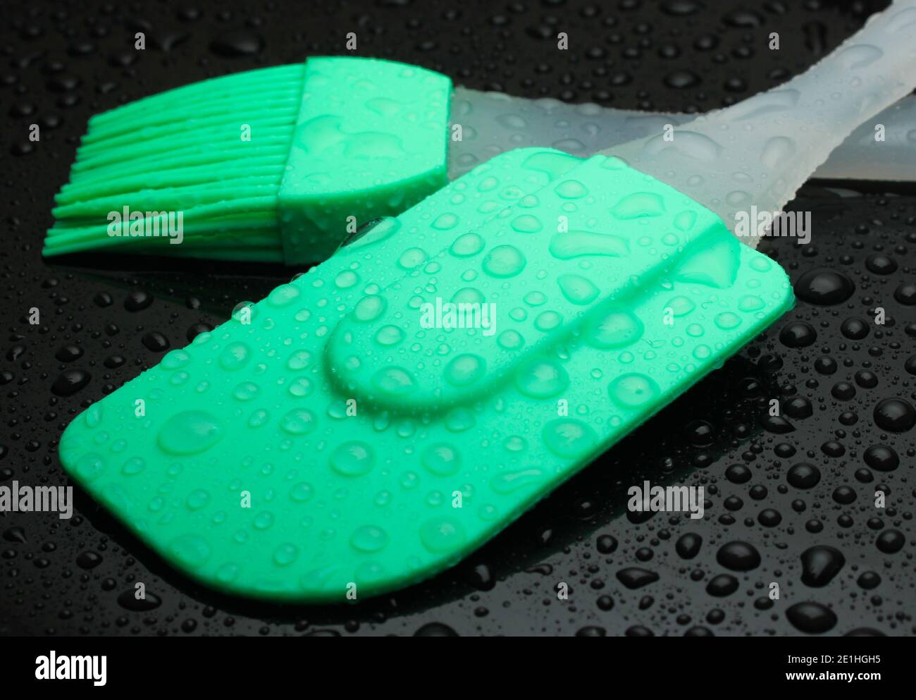 Kitchen tools in water drops on black background. Silicone spatula ...