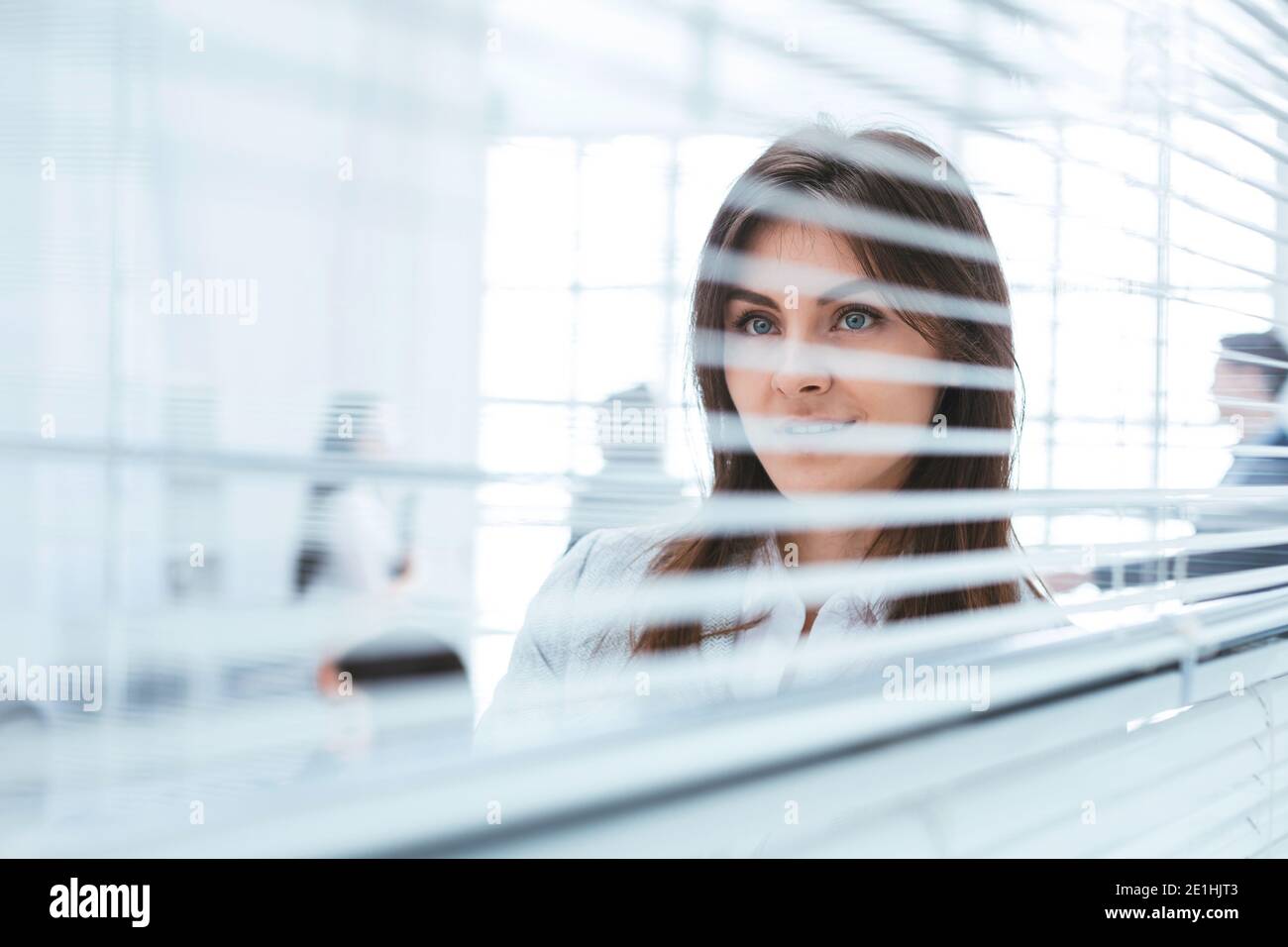 young business woman looking through office window Stock Photo - Alamy