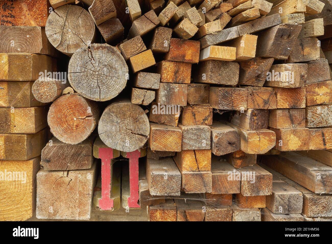 Stack of old saw timber. Round timber, wooden boards and beams Stock ...