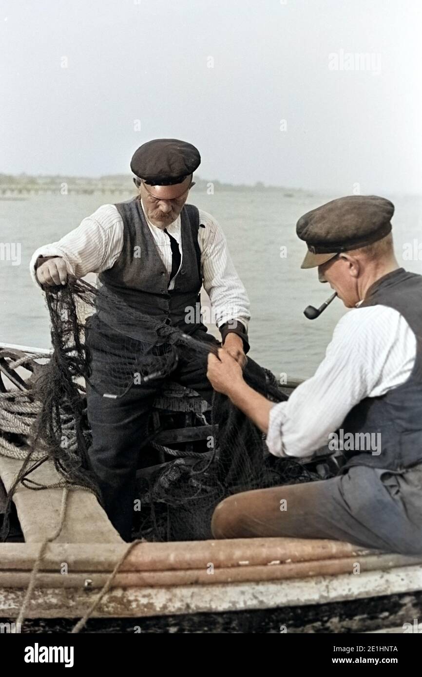 Fischer sortieren ihre Netze bevor sie sie zum Fischfang ins Meer ...