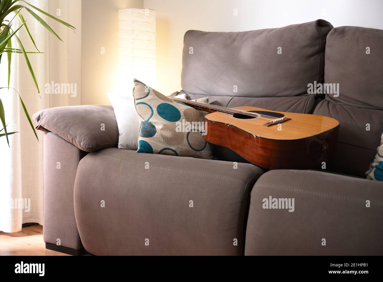 Room with an acoustic guitar on a sofa in a warm environment Stock ...