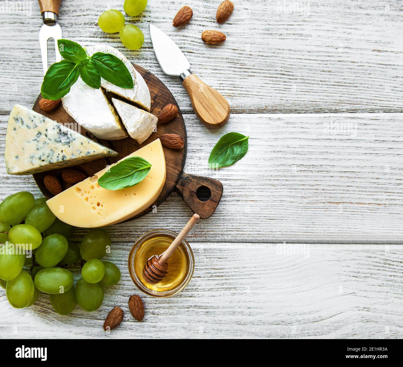 Different types of cheese with snacks on an white old wooden table ...