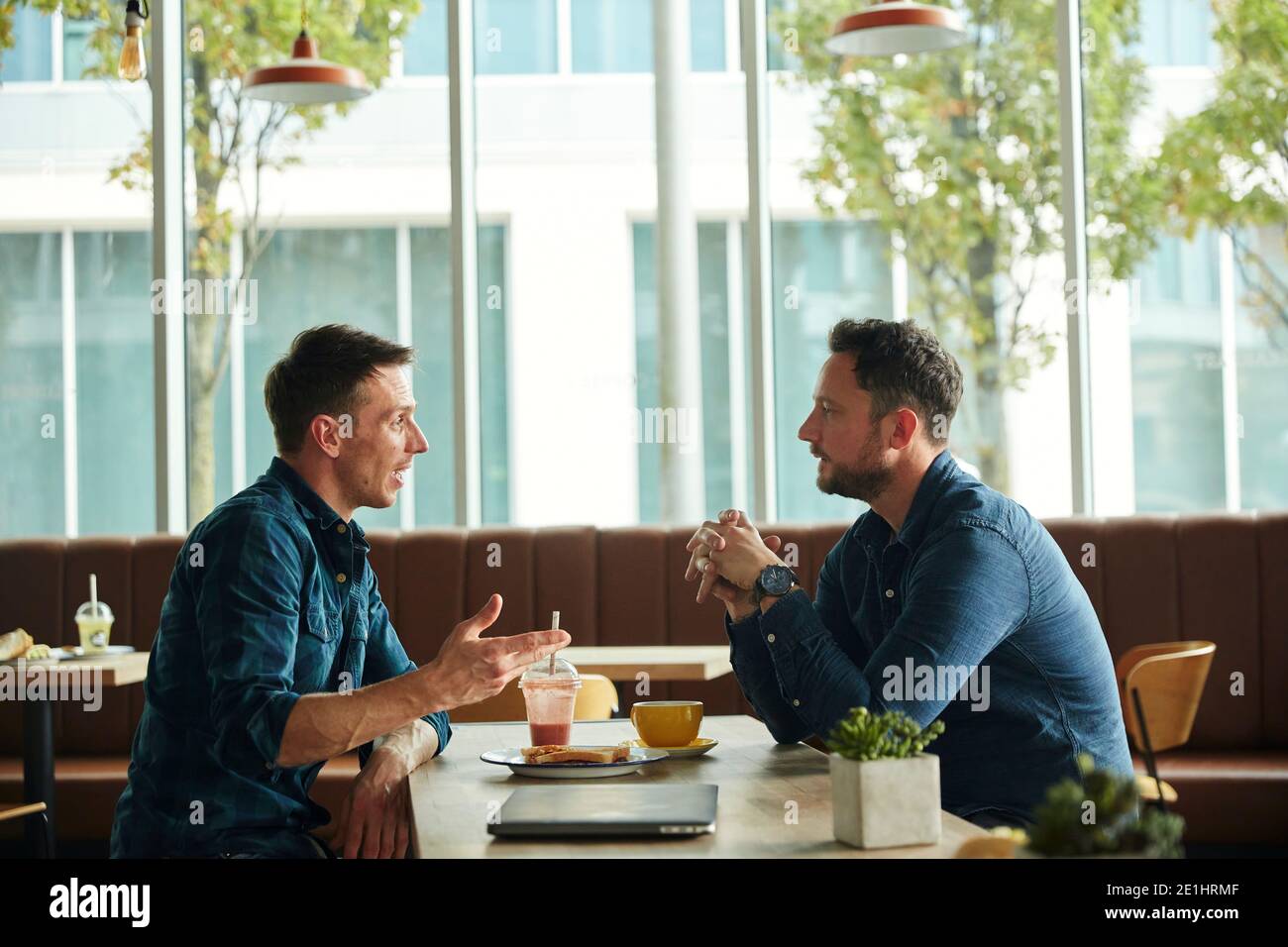 Two men seated in a cafe talking, having a meeting Stock Photo - Alamy