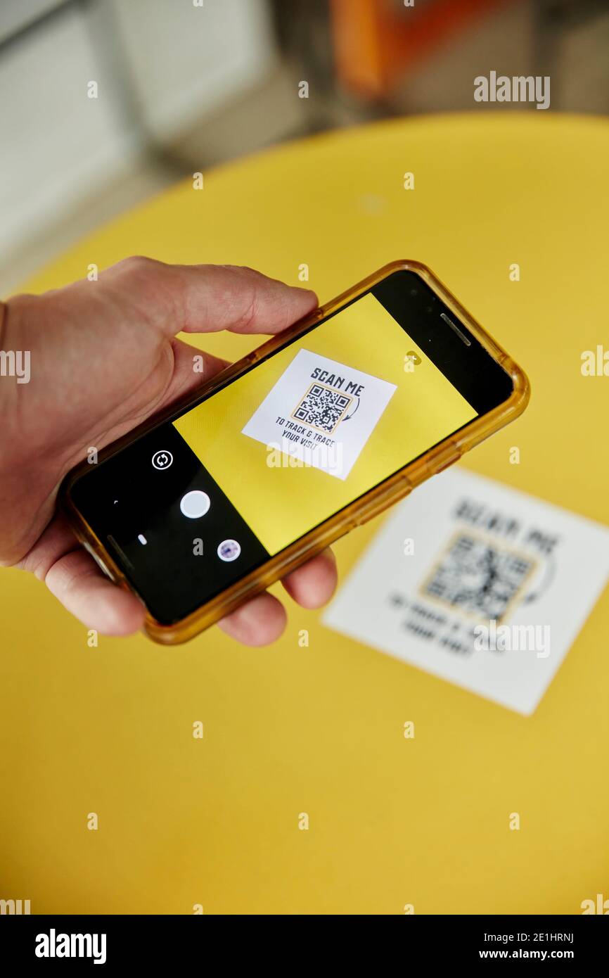 A person uisng a smart phone, taking a photograph of a Track and Trace ...