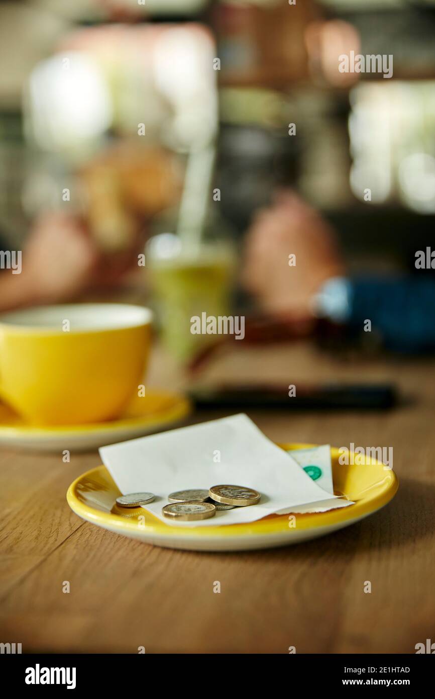 Coins and bill on cafe table Stock Photo - Alamy