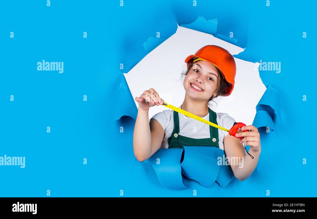 cheerful child laborer using building uniform and tape measure, copy ...