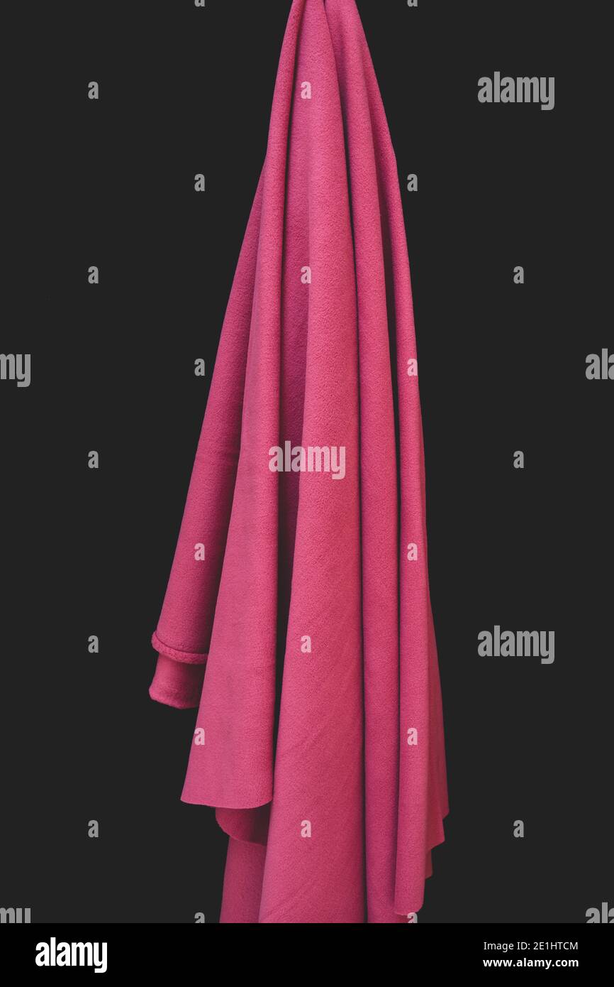 Detail of hanging pink fabric against black background Stock Photo - Alamy