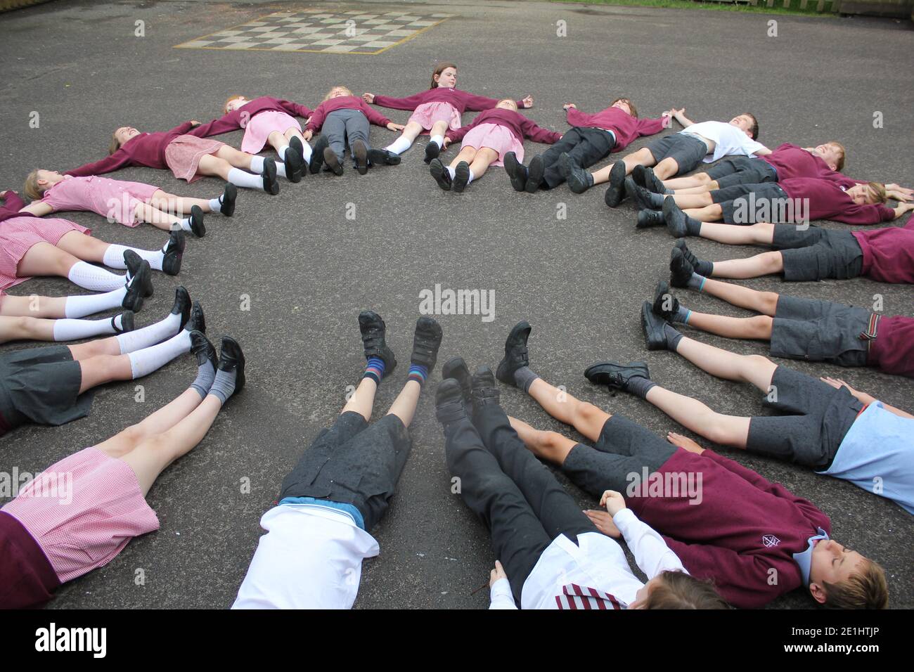 Children lying on the school playground in a circle Stock Photo - Alamy