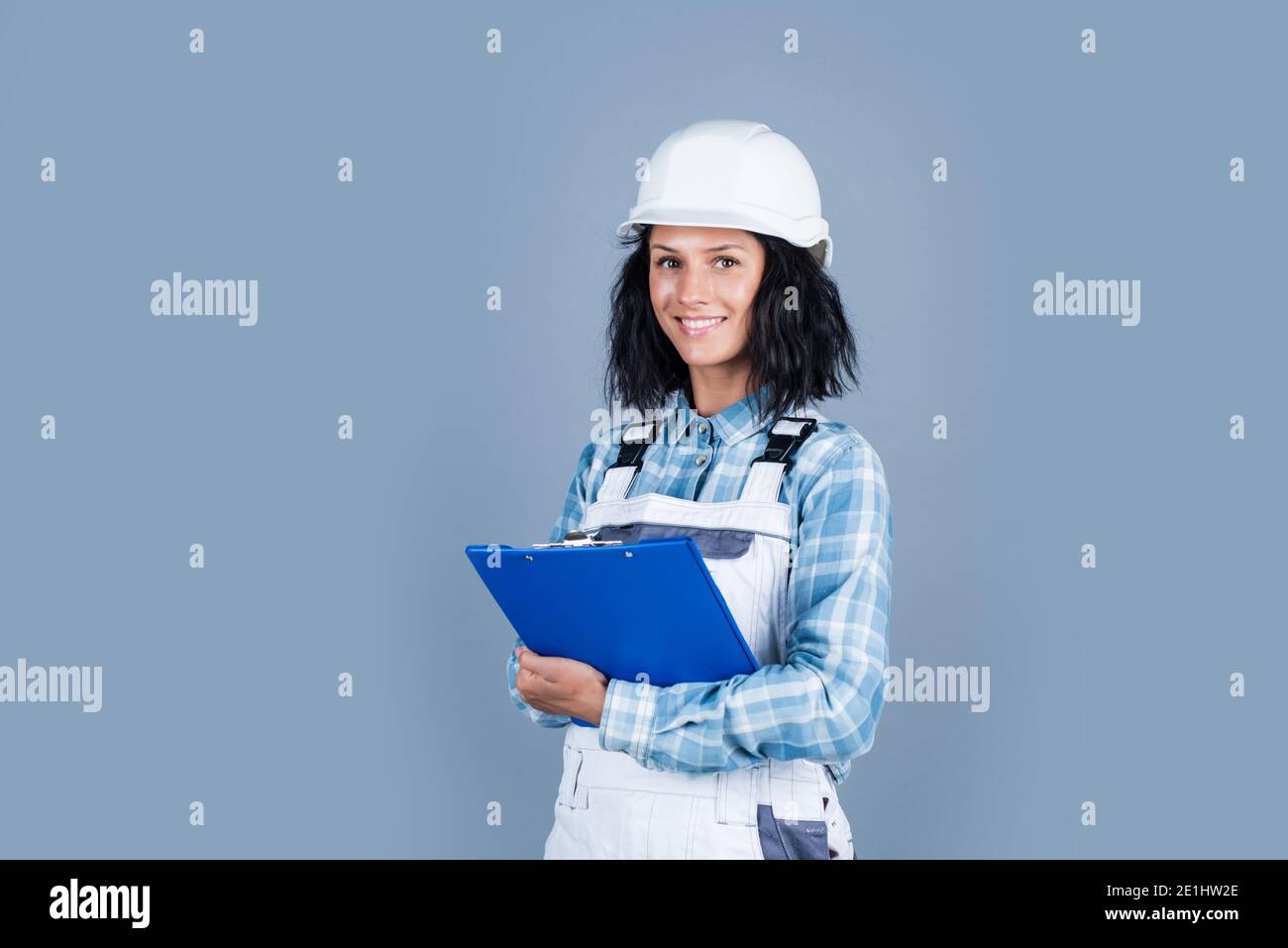 Foreman inspector. girl in checkered shirt and protective hard hat ...