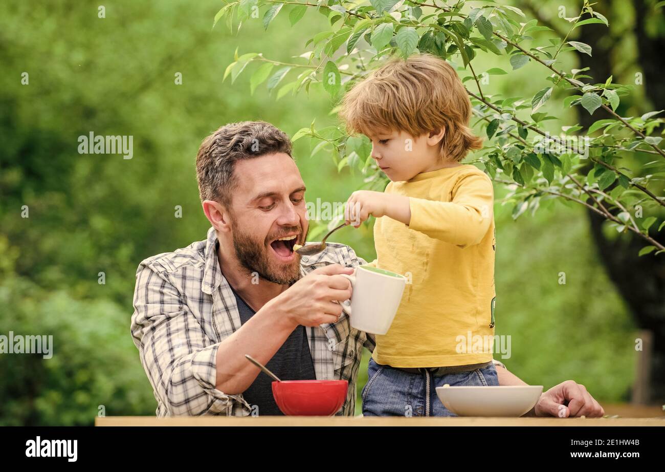 Family enjoy homemade meal. Food habits. Little boy with dad eating ...