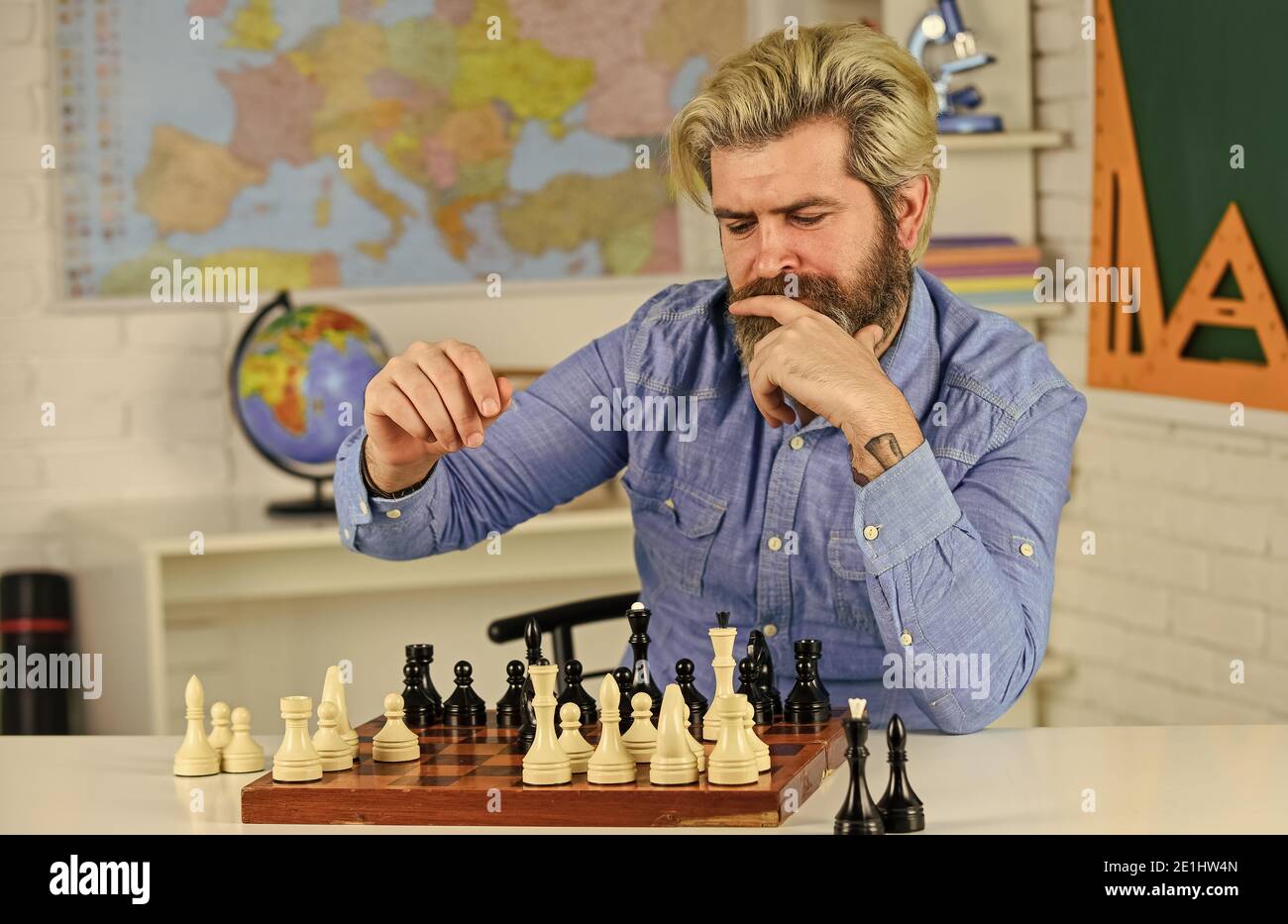 Figures on wooden chess board. Smart hipster man playing chess ...