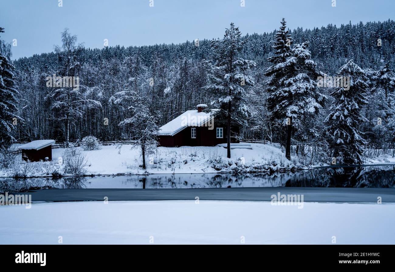 Cozy cabin by a frozen lake in a winter wilderness landscape Stock ...