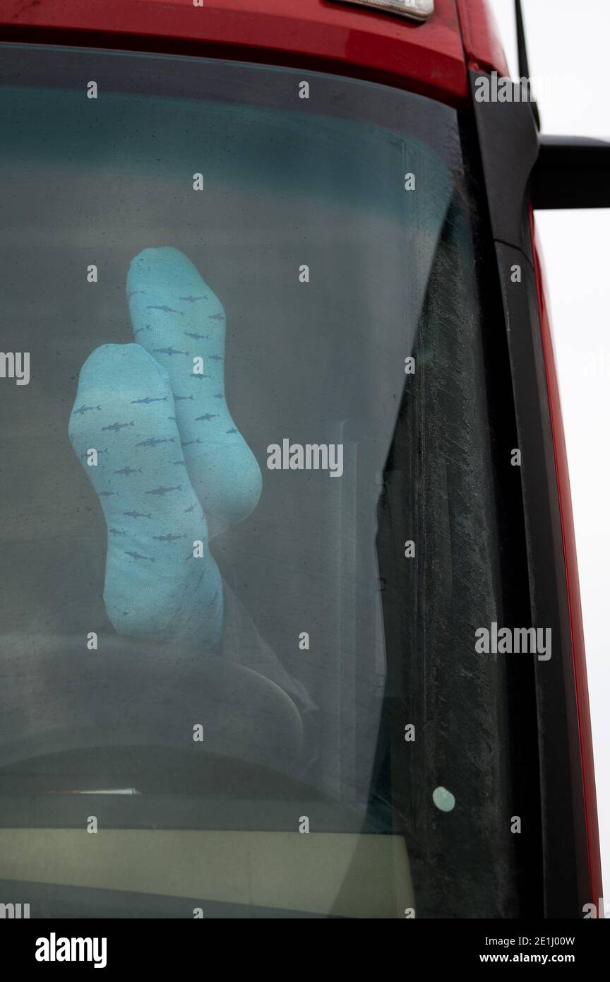 Sindelfingen, Germany. 07th Jan, 2021. A truck driver puts his feet on ...