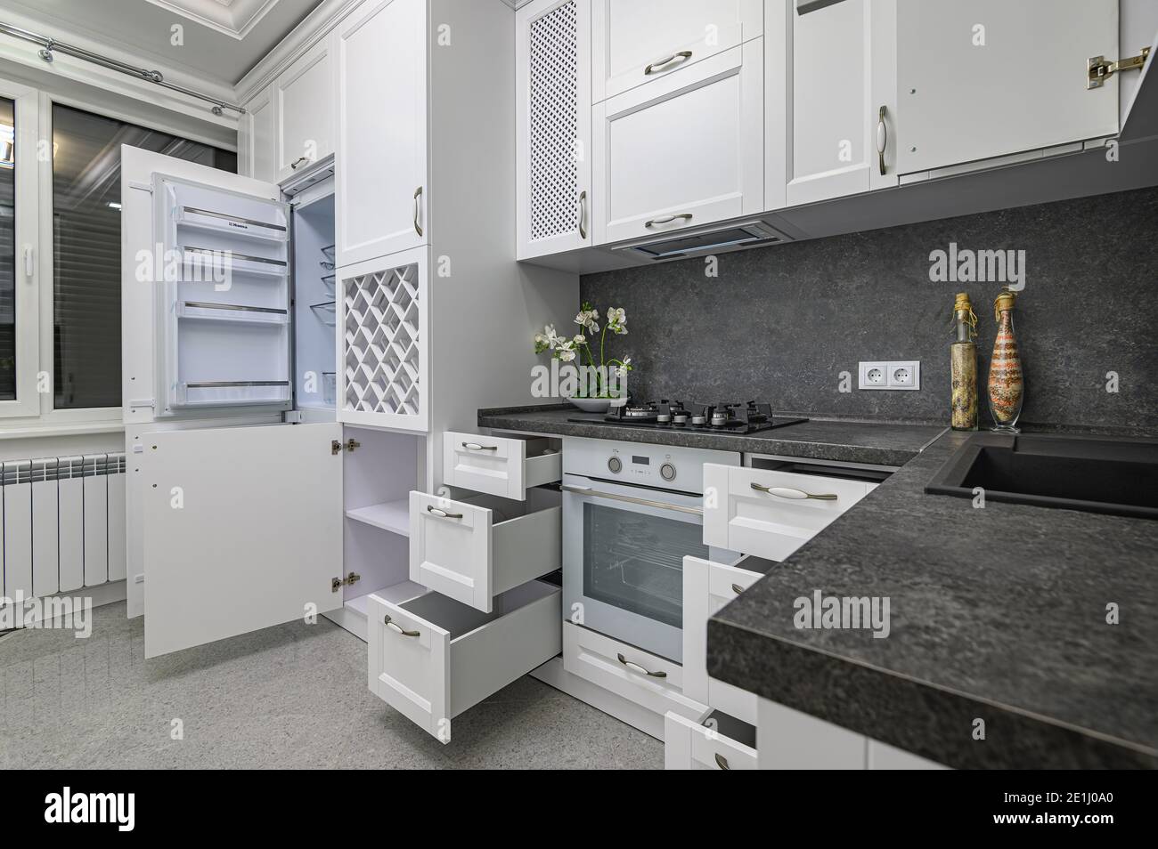 Open doors and drawers open at modern white kitchen Stock Photo - Alamy