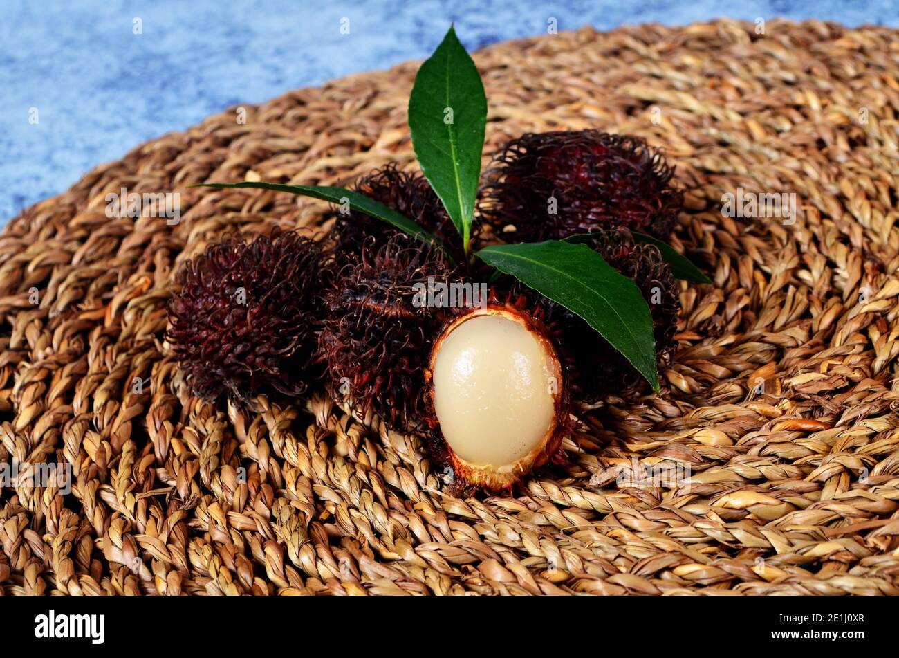 Very ripe rambutan fruit on a blue stone background Stock Photo - Alamy