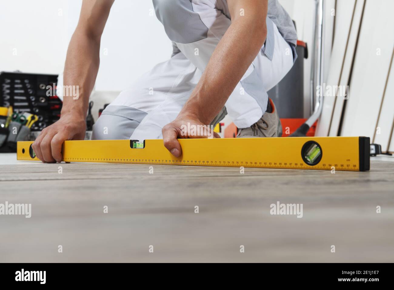 man worker hands installing timber laminate floor. Precise finishing ...
