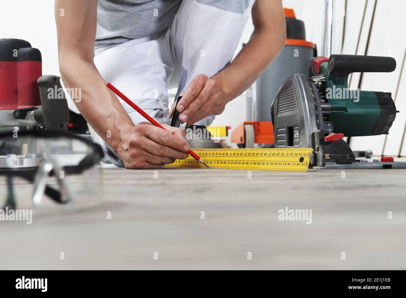 man worker hands installing timber laminate floor, takes measurement ...