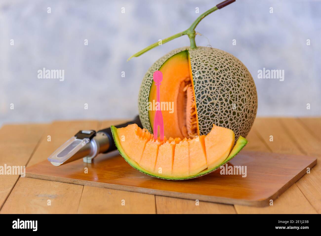 split the orange melon on wood plate Stock Photo - Alamy