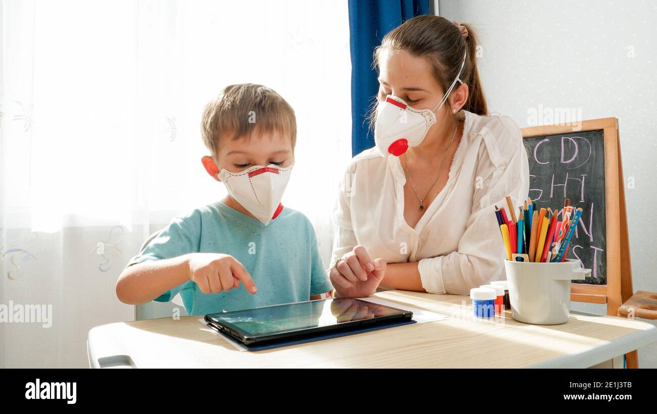 Little boy wearing protective medical mask respirator studying in ...