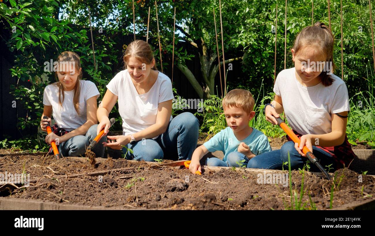 Big family with children working in house backyard garden and digging ...
