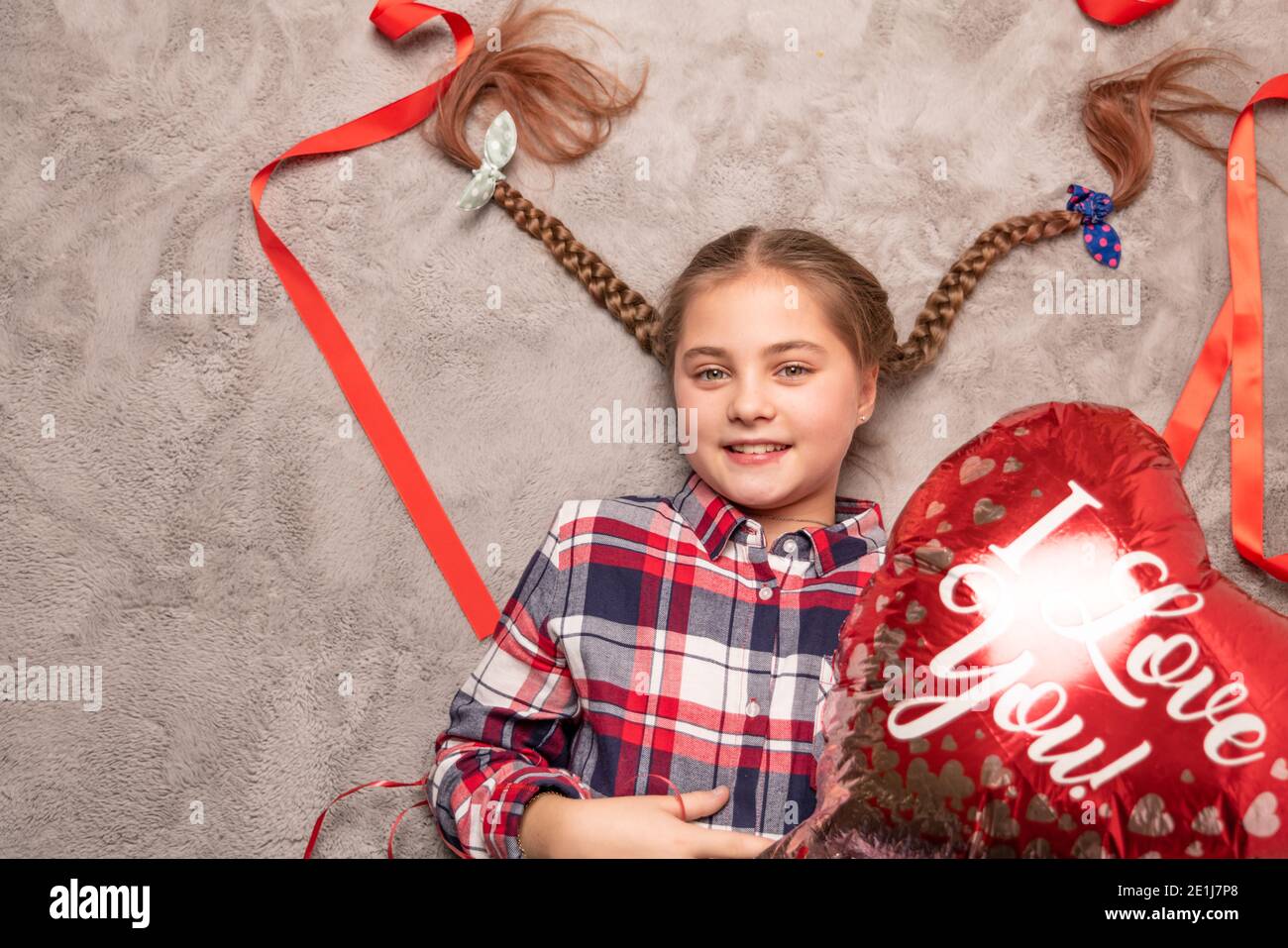 cute smiling girl holding red heart shaped balloon. Caucasian beautiful ...