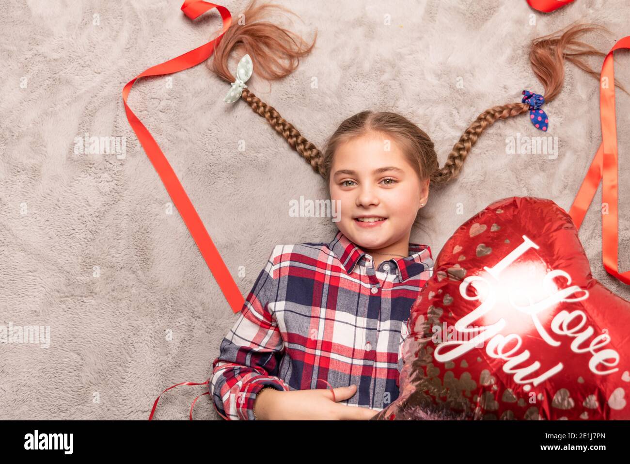 cute smiling girl holding red heart shaped balloon. Caucasian beautiful ...