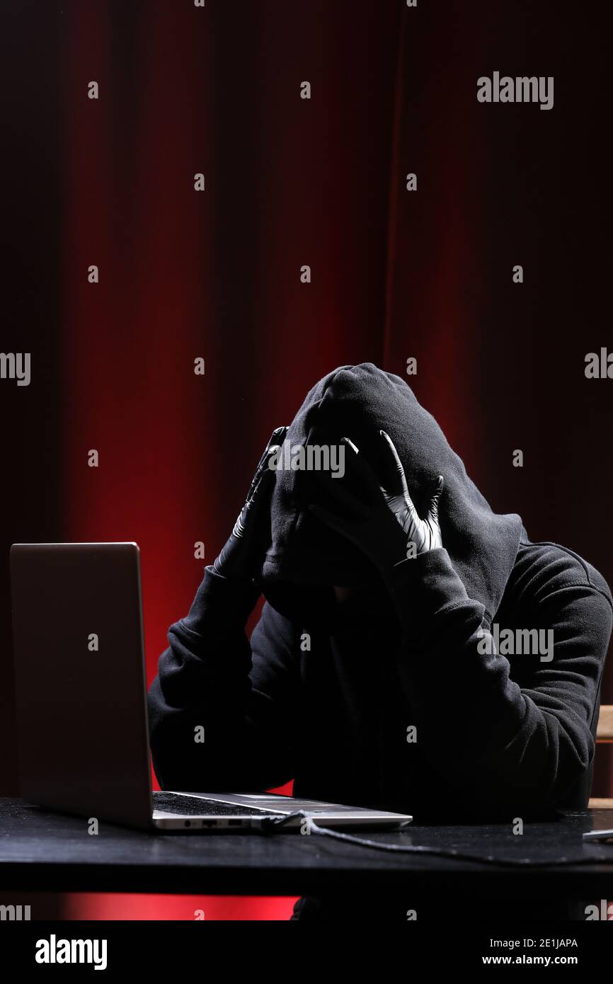 International hacker in black pullover and black mask trying to hack ...